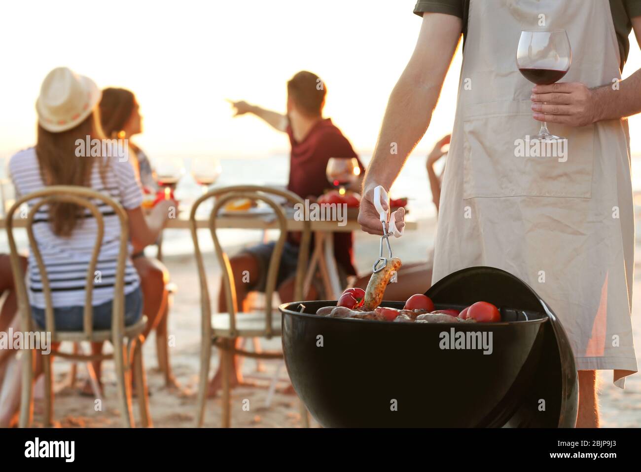 Young people having barbecue party on beach Stock Photo - Alamy