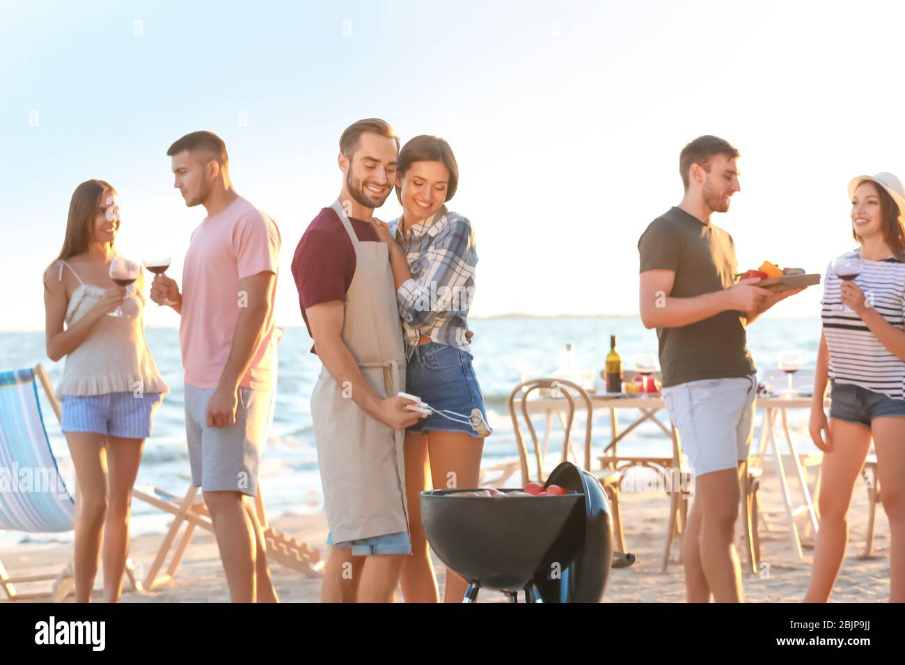 Young people having barbecue party on beach Stock Photo - Alamy