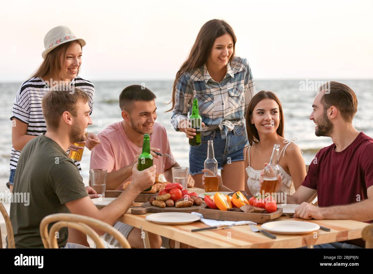 Young people having barbecue party on beach Stock Photo - Alamy