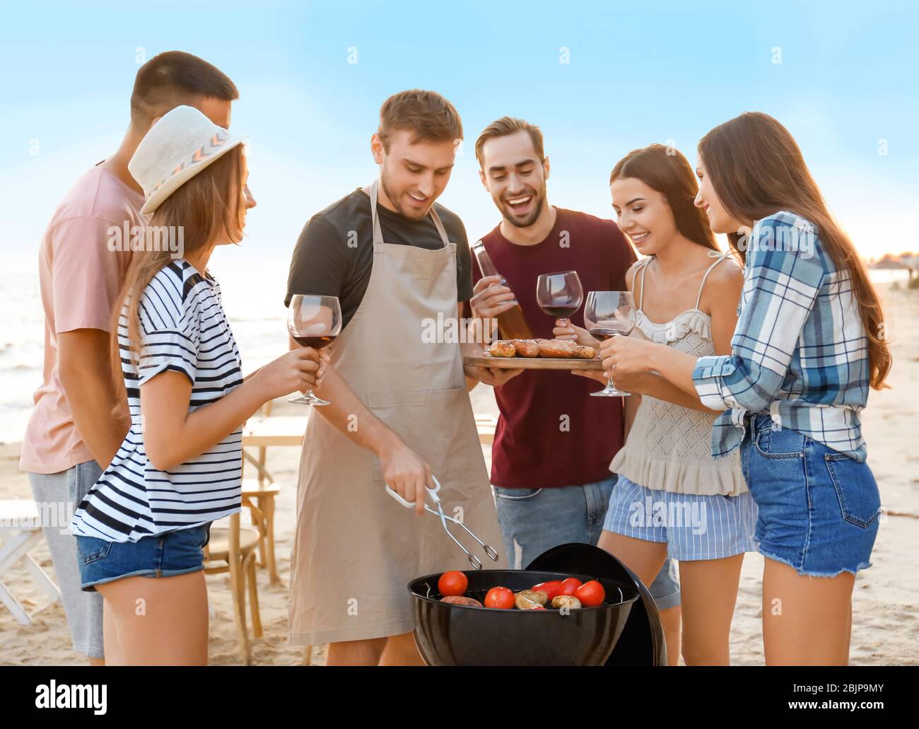 Young people having barbecue party on beach Stock Photo - Alamy