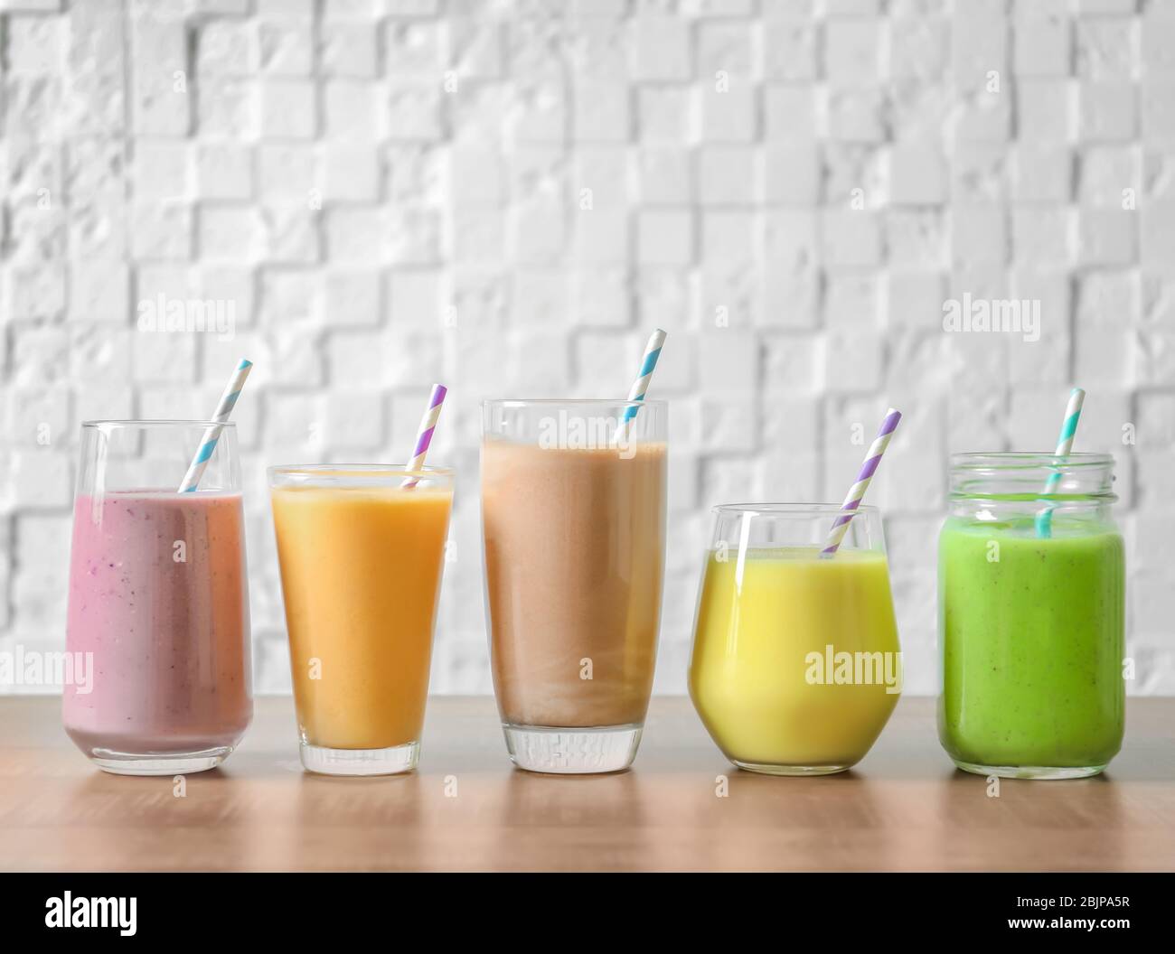 Different milkshakes in glassware on table Stock Photo - Alamy