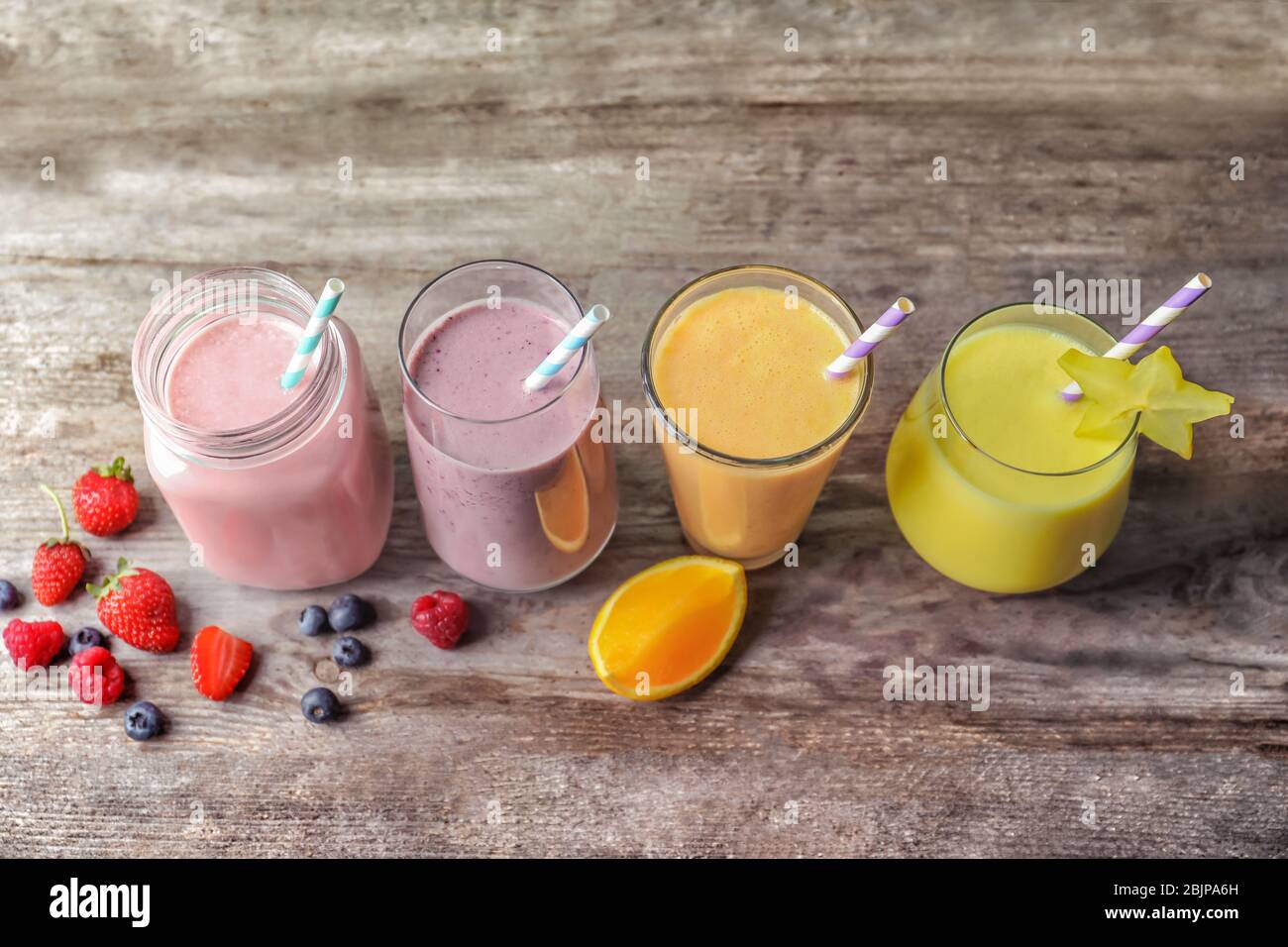Different milkshakes in glassware on wooden background Stock Photo - Alamy