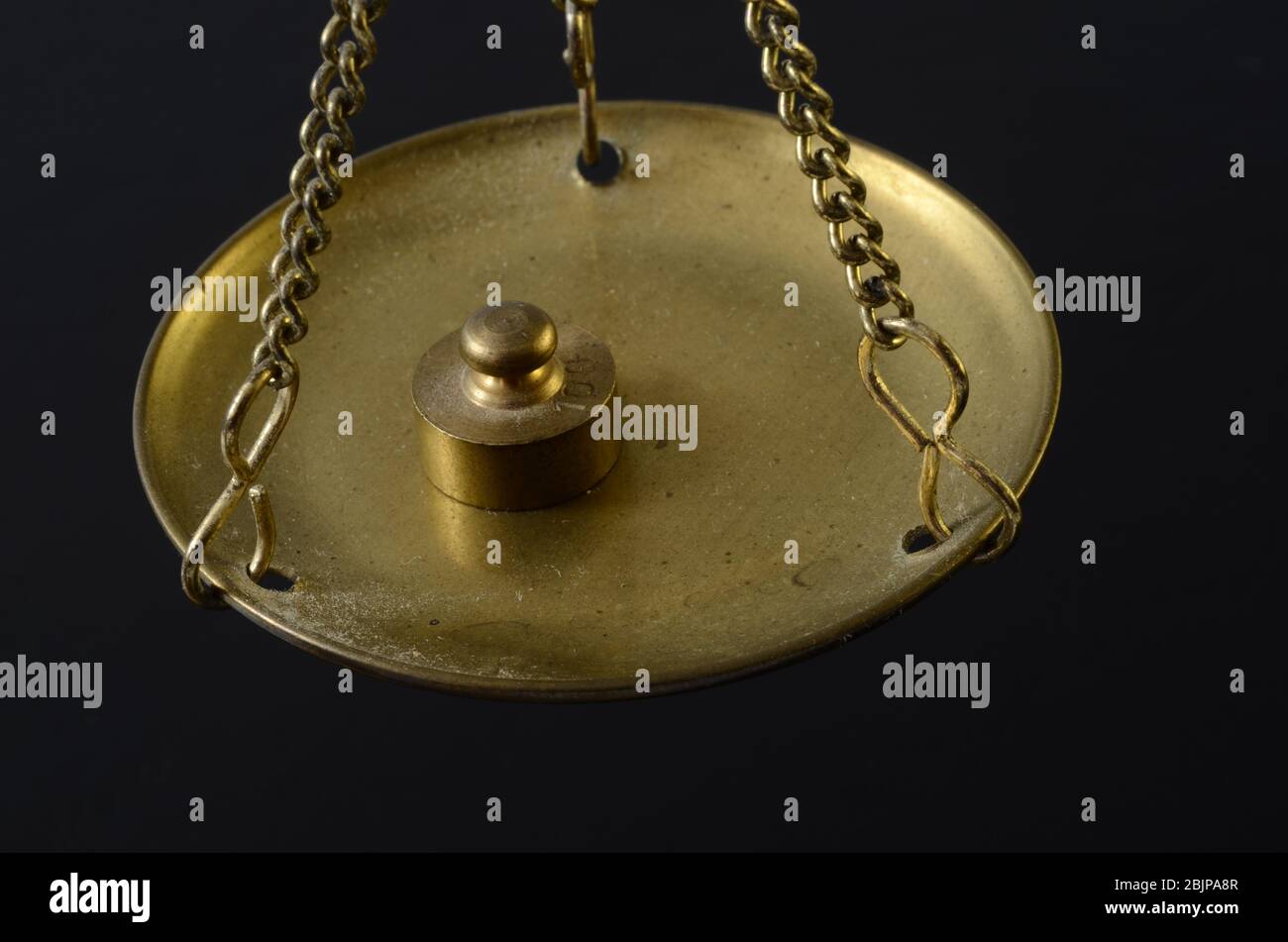 Golden weighing scale and weights on black background Stock Photo - Alamy