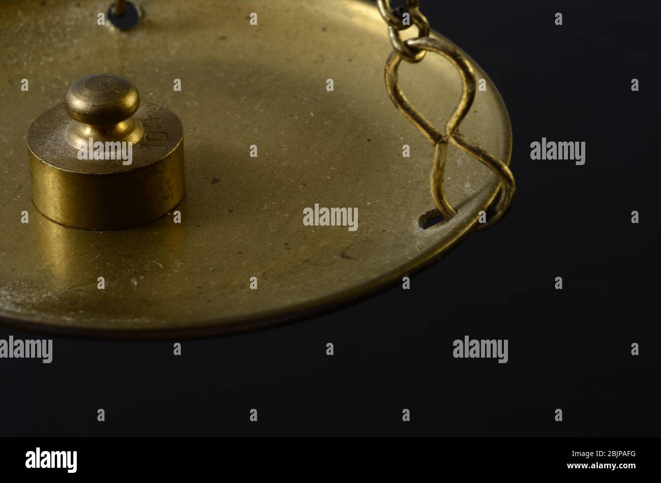 Golden weighing scale and weights on black background Stock Photo - Alamy