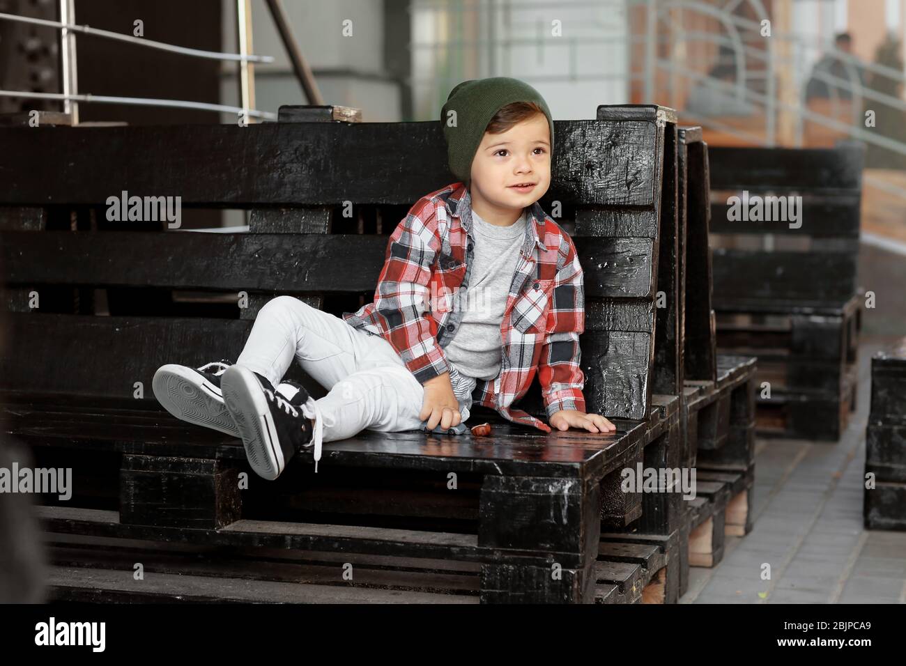 Adorable little boy sitting on bench in outdoor cafe Stock Photo - Alamy