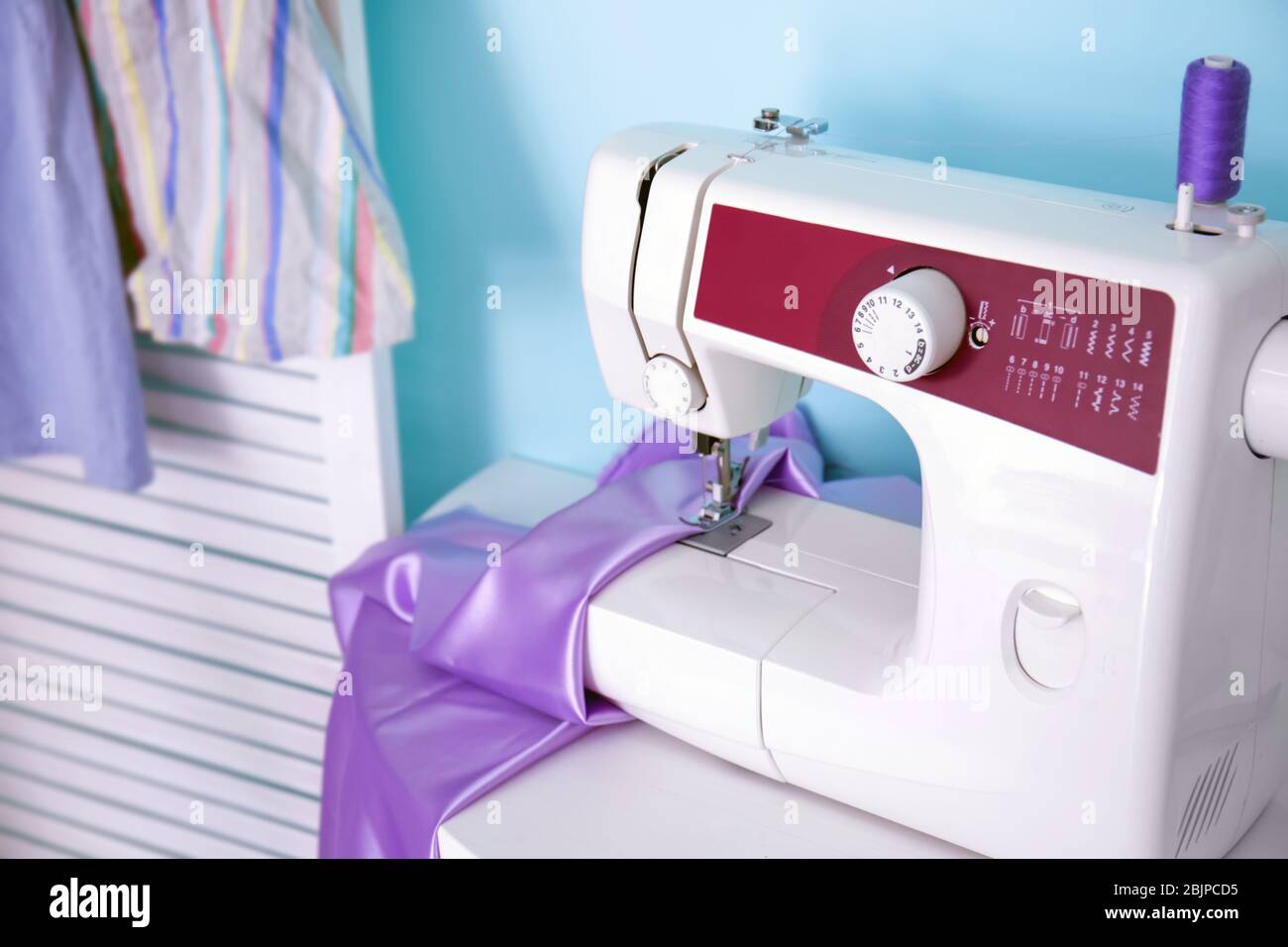Sewing machine on table in tailor's workshop Stock Photo - Alamy