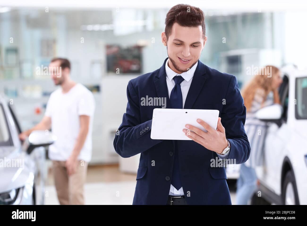Car salesman with tablet in dealership Stock Photo - Alamy