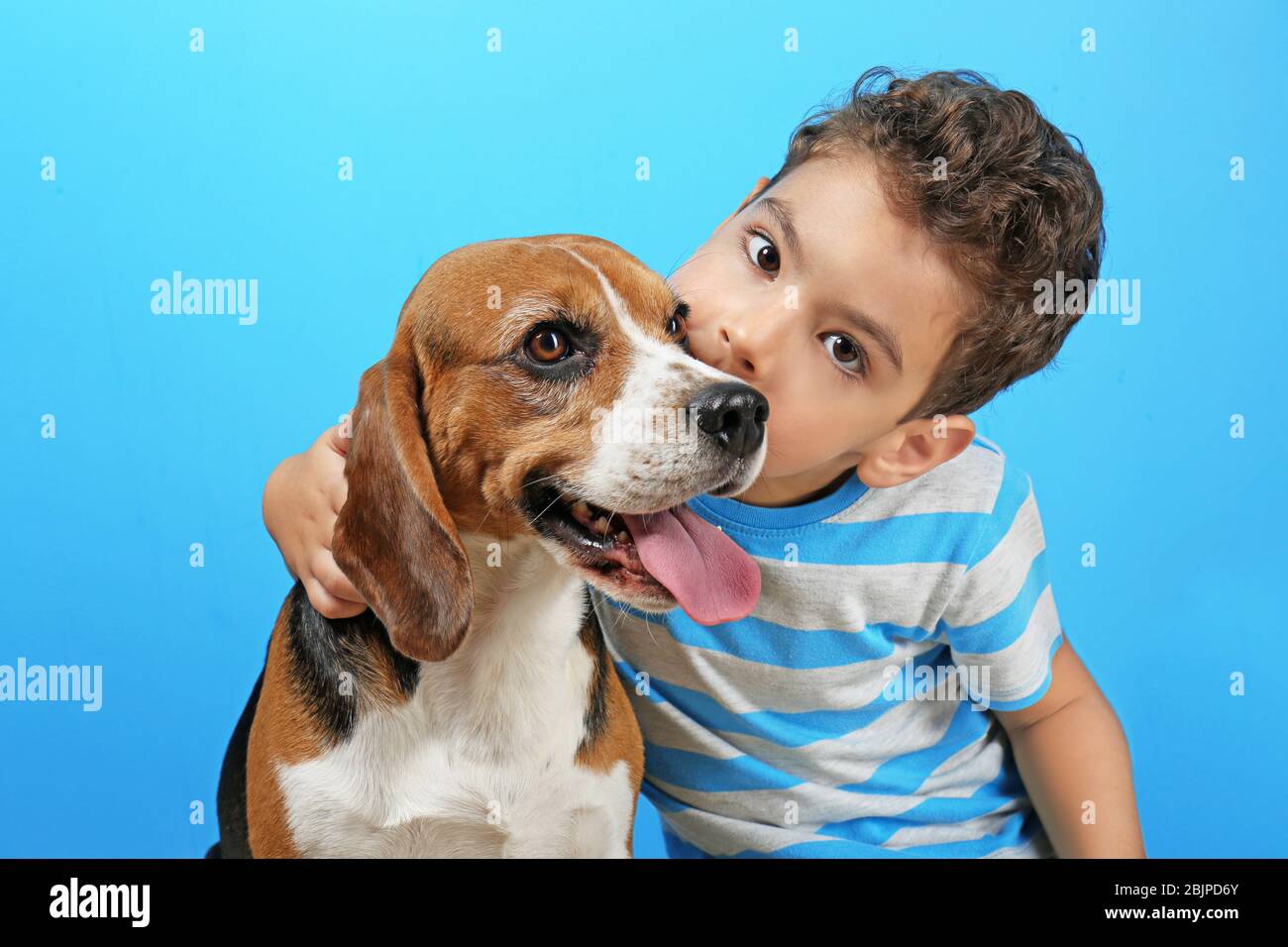 Cute boy with dog on color background Stock Photo - Alamy