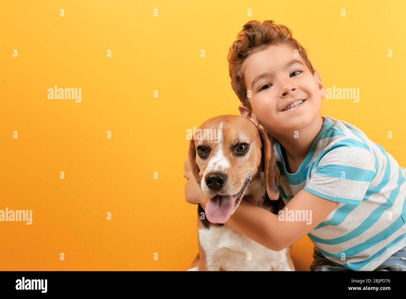 Cute boy with dog on color background Stock Photo - Alamy