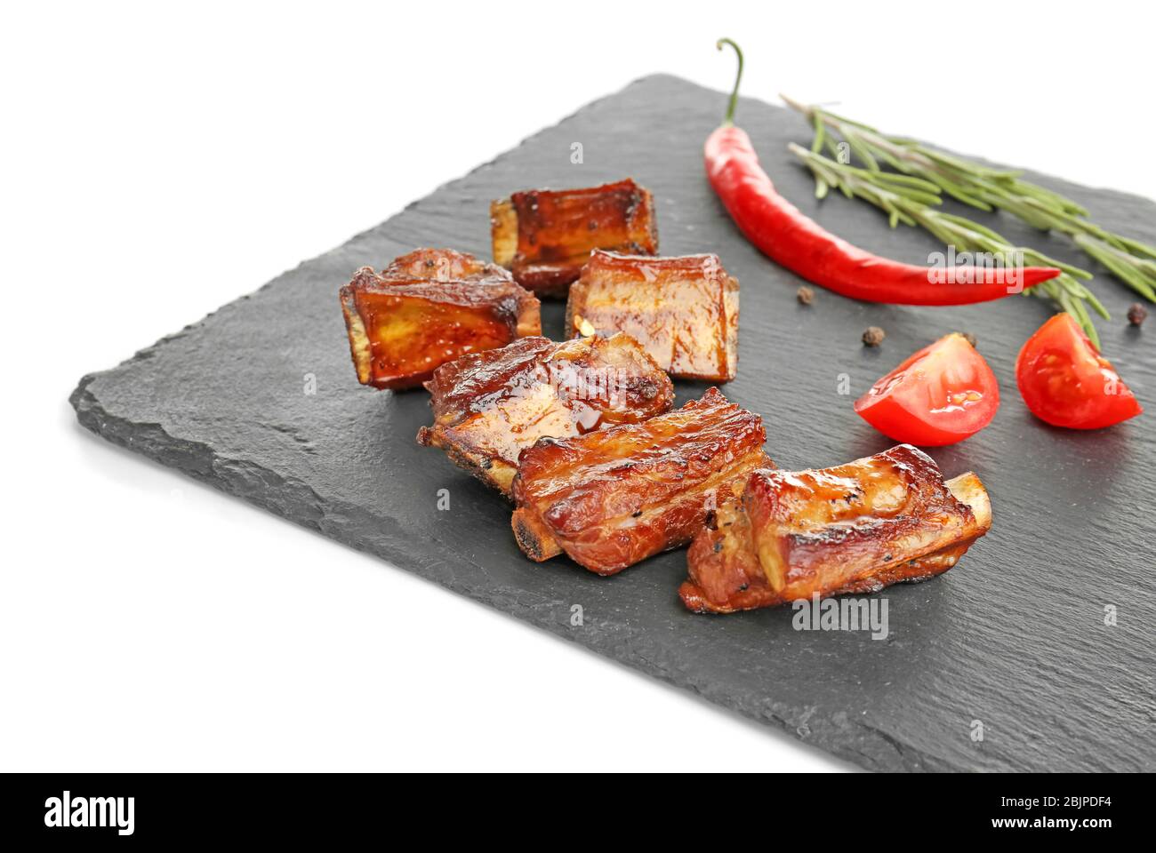 Slate plate with delicious grilled ribs on white background Stock Photo ...