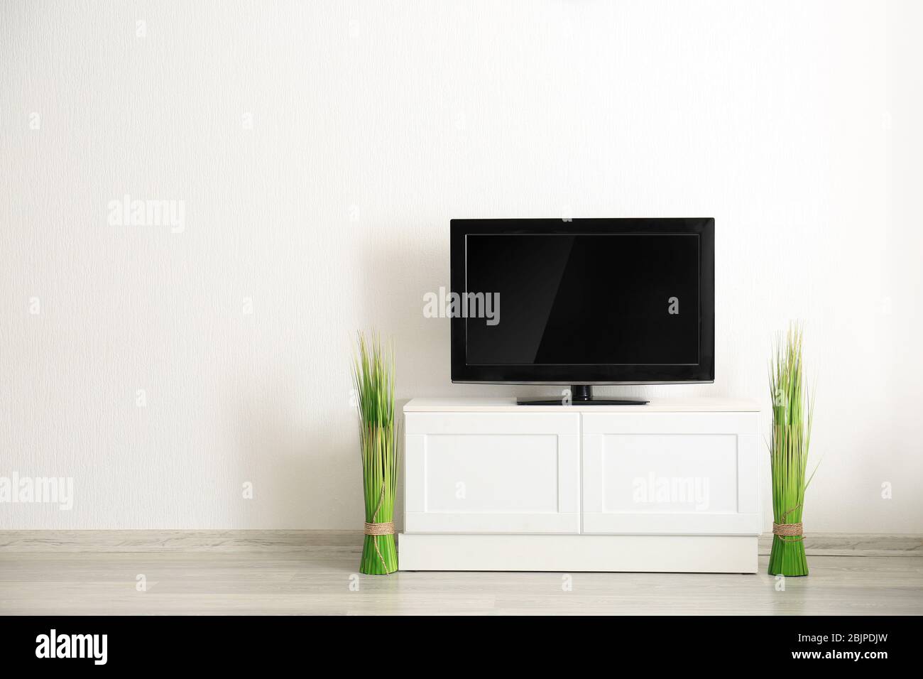 Modern TV set on stand in living room Stock Photo - Alamy