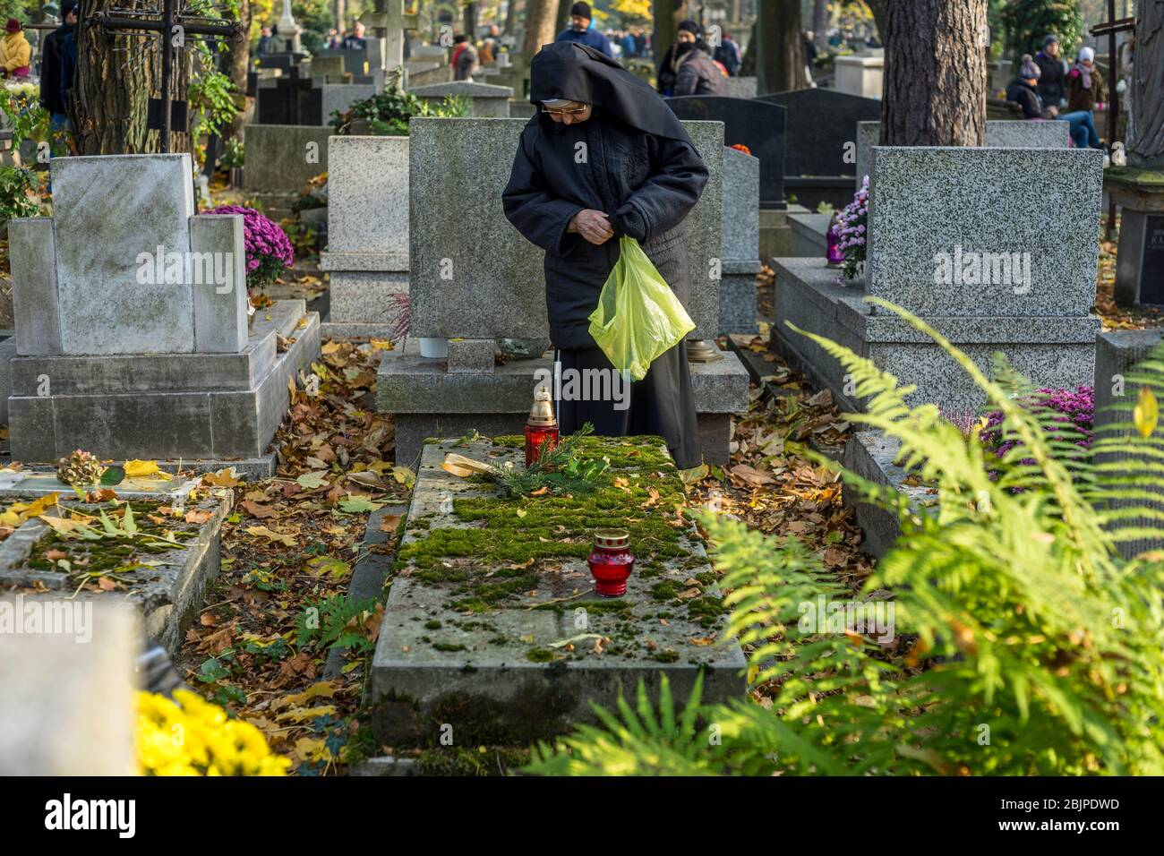 A nun remembers her deceased loved ones at Rakowicki Cemetery in Krakow ...