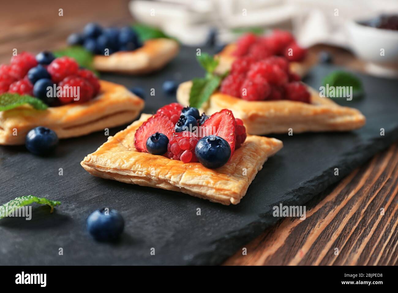 Yummy puff pastry with berries on slate plate Stock Photo - Alamy
