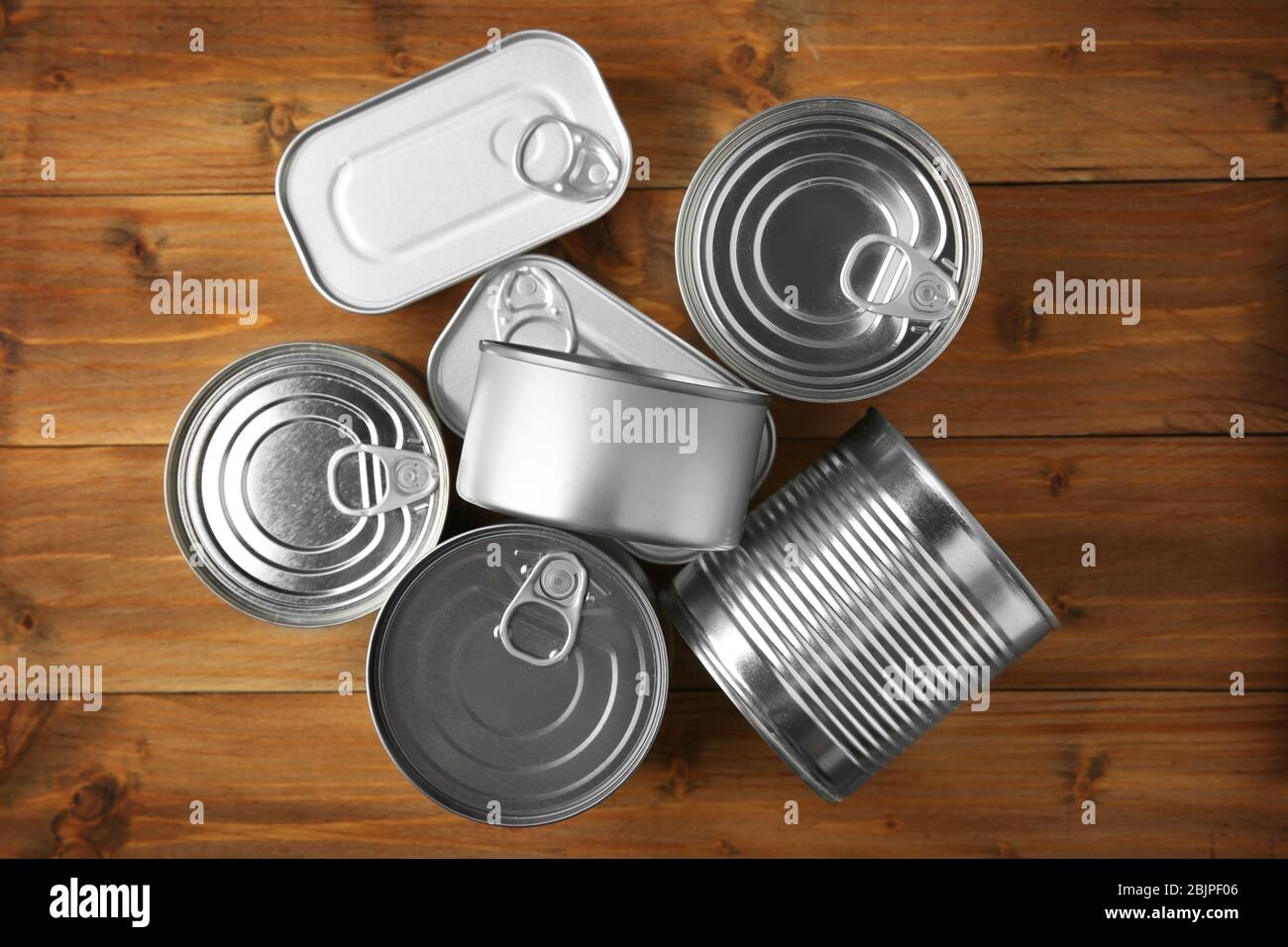 Tin cans on wooden background Stock Photo - Alamy