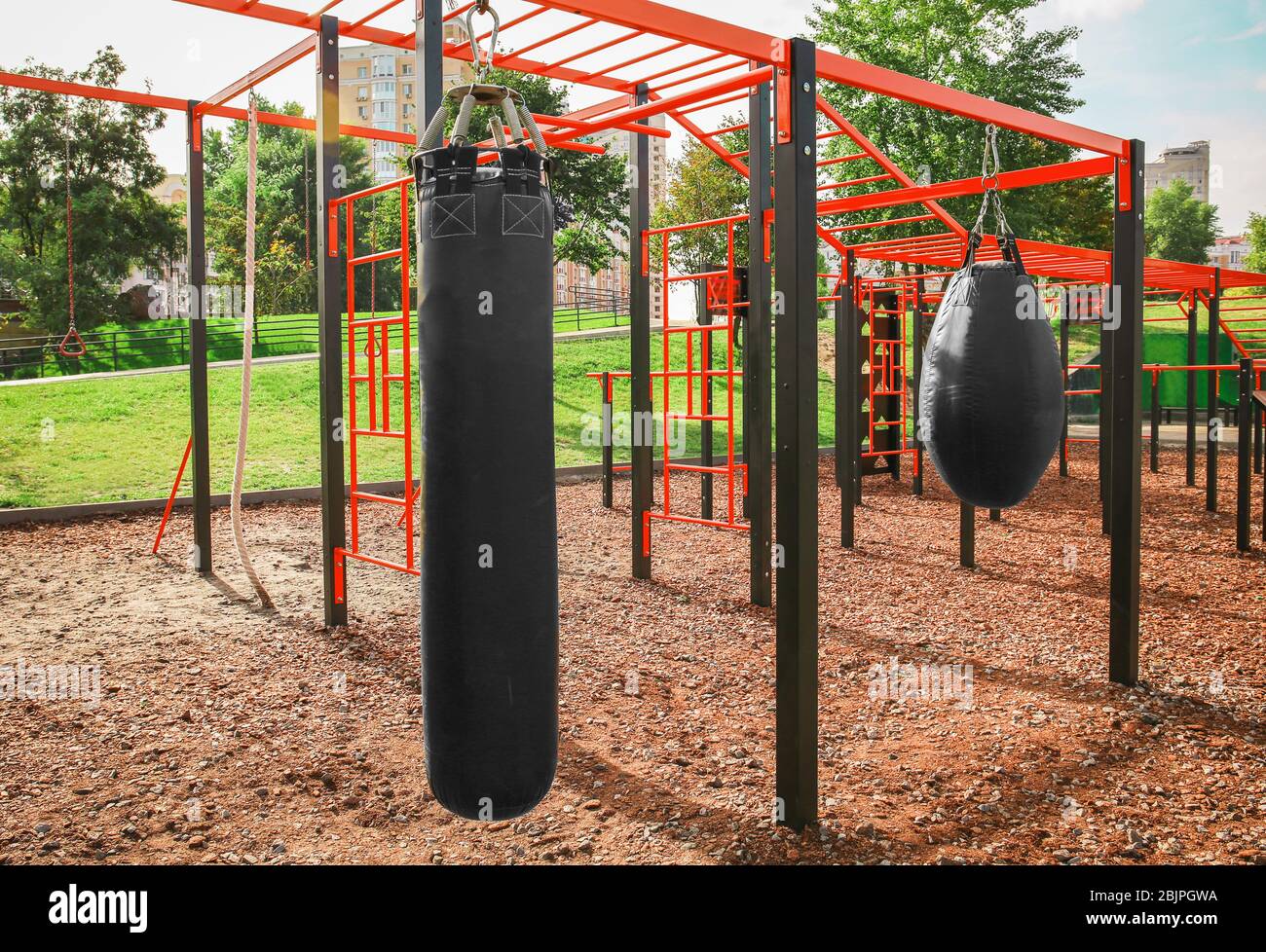 Punching bags for boxing on athletic field in park Stock Photo - Alamy