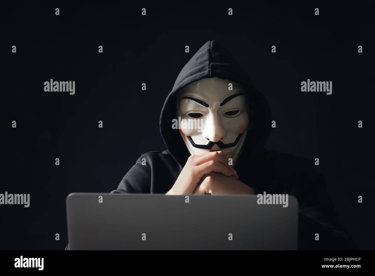 Hacker anonymous mask using laptop hi-res stock photography and images ...