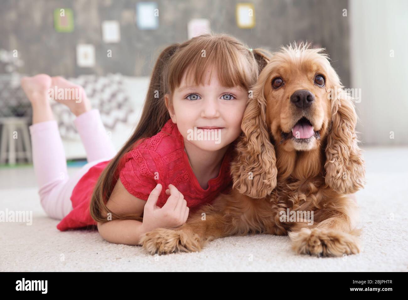 Cute little girl with dog at home Stock Photo - Alamy