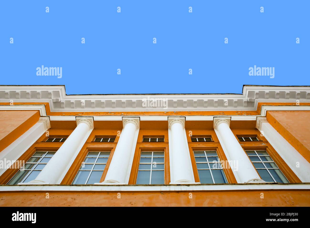 Beautiful building with columns against blue sky Stock Photo - Alamy