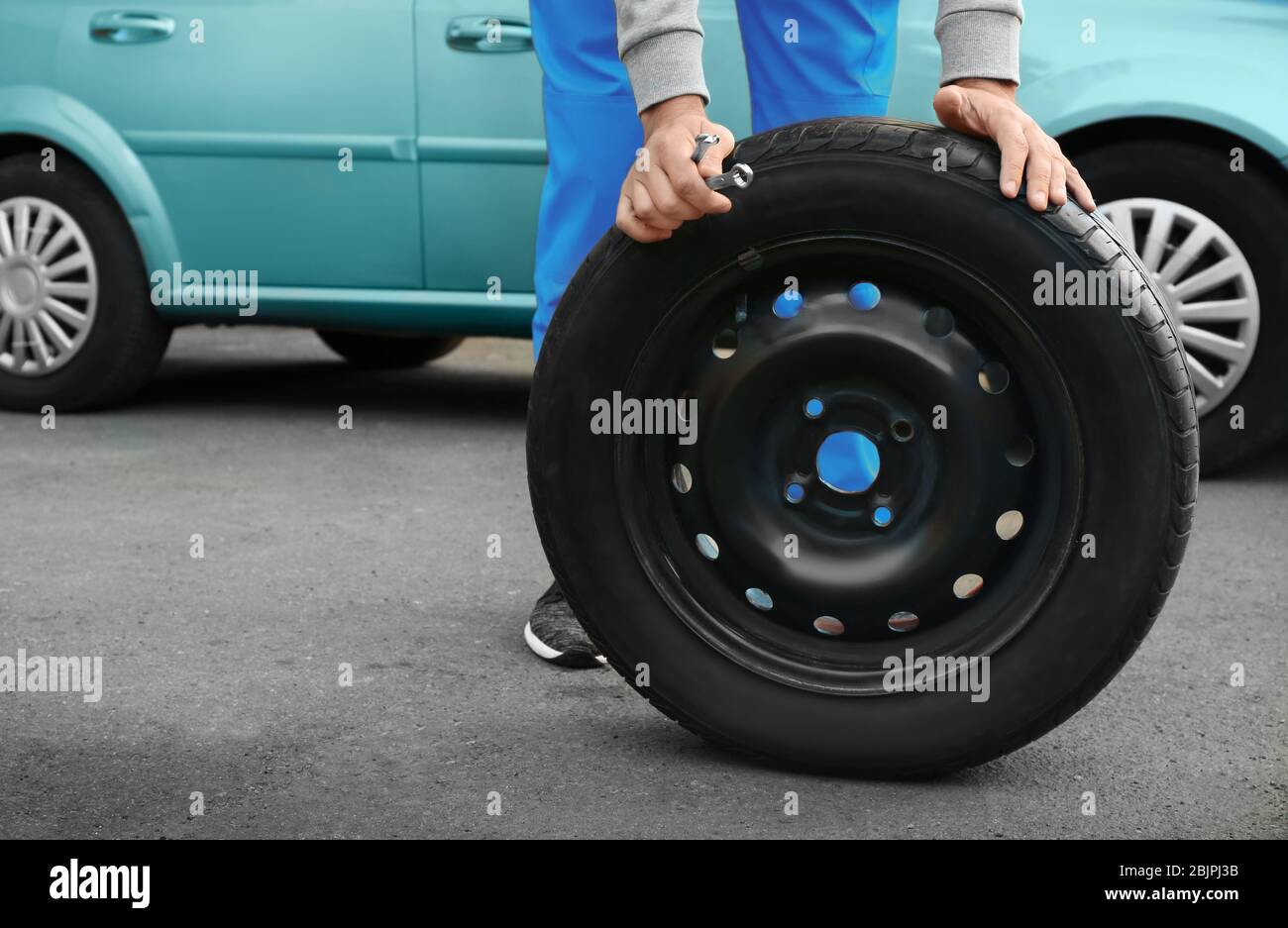 Young male mechanic changing wheel at service station Stock Photo - Alamy