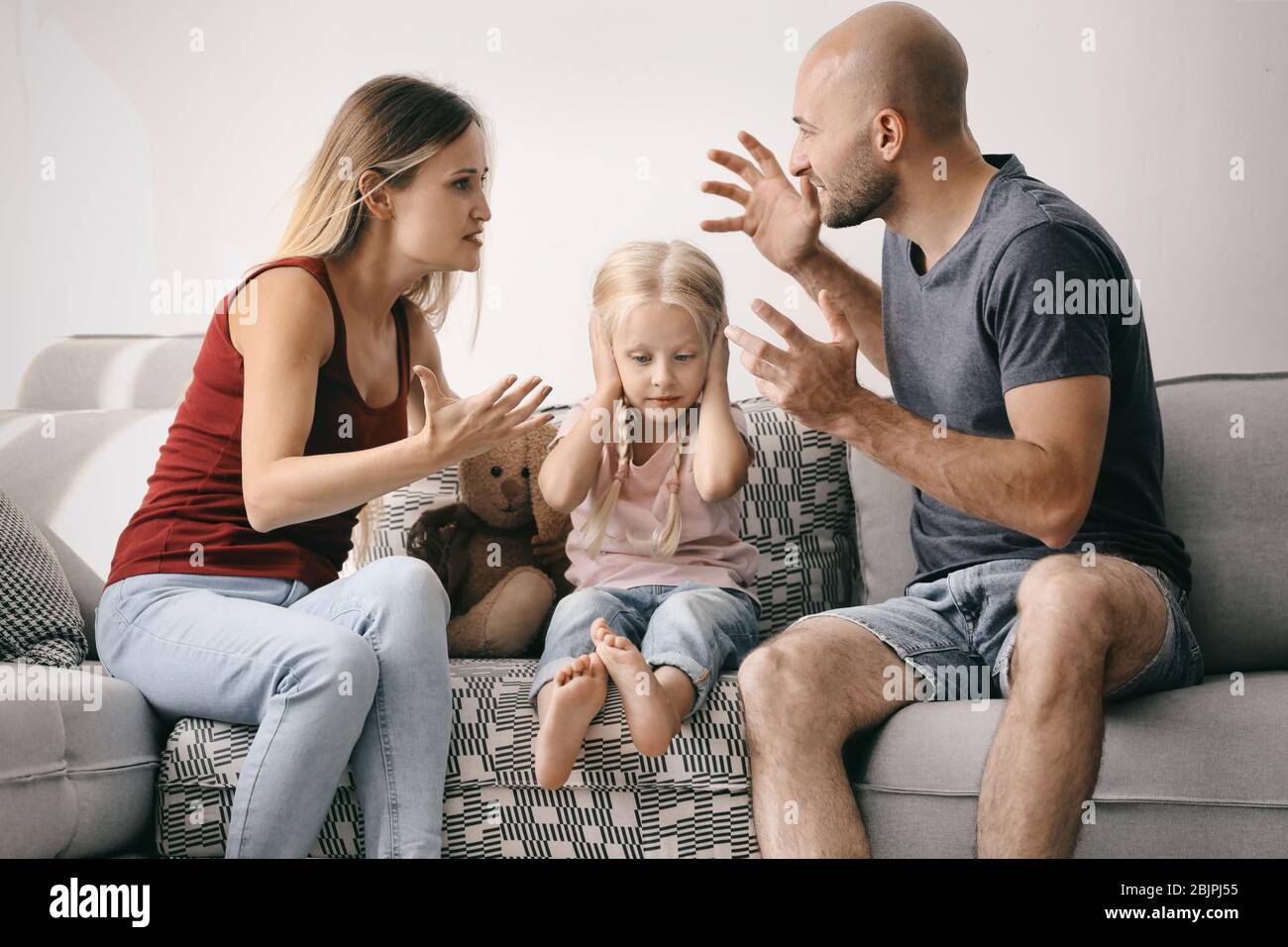 Little girl between arguing parents at home Stock Photo - Alamy