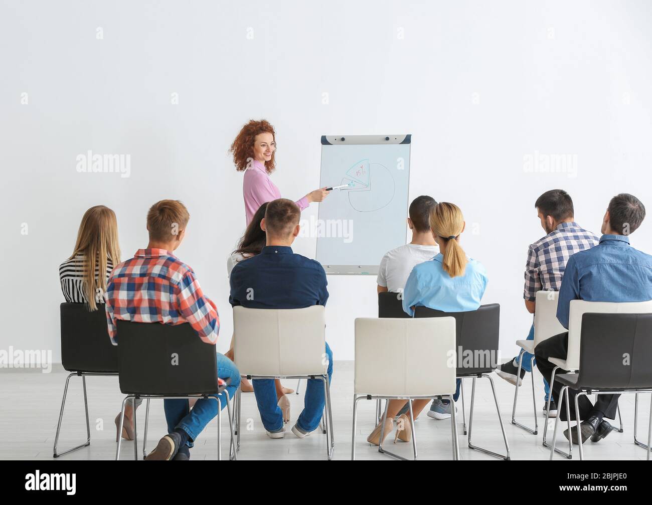 Group of people with business trainer at seminar Stock Photo - Alamy