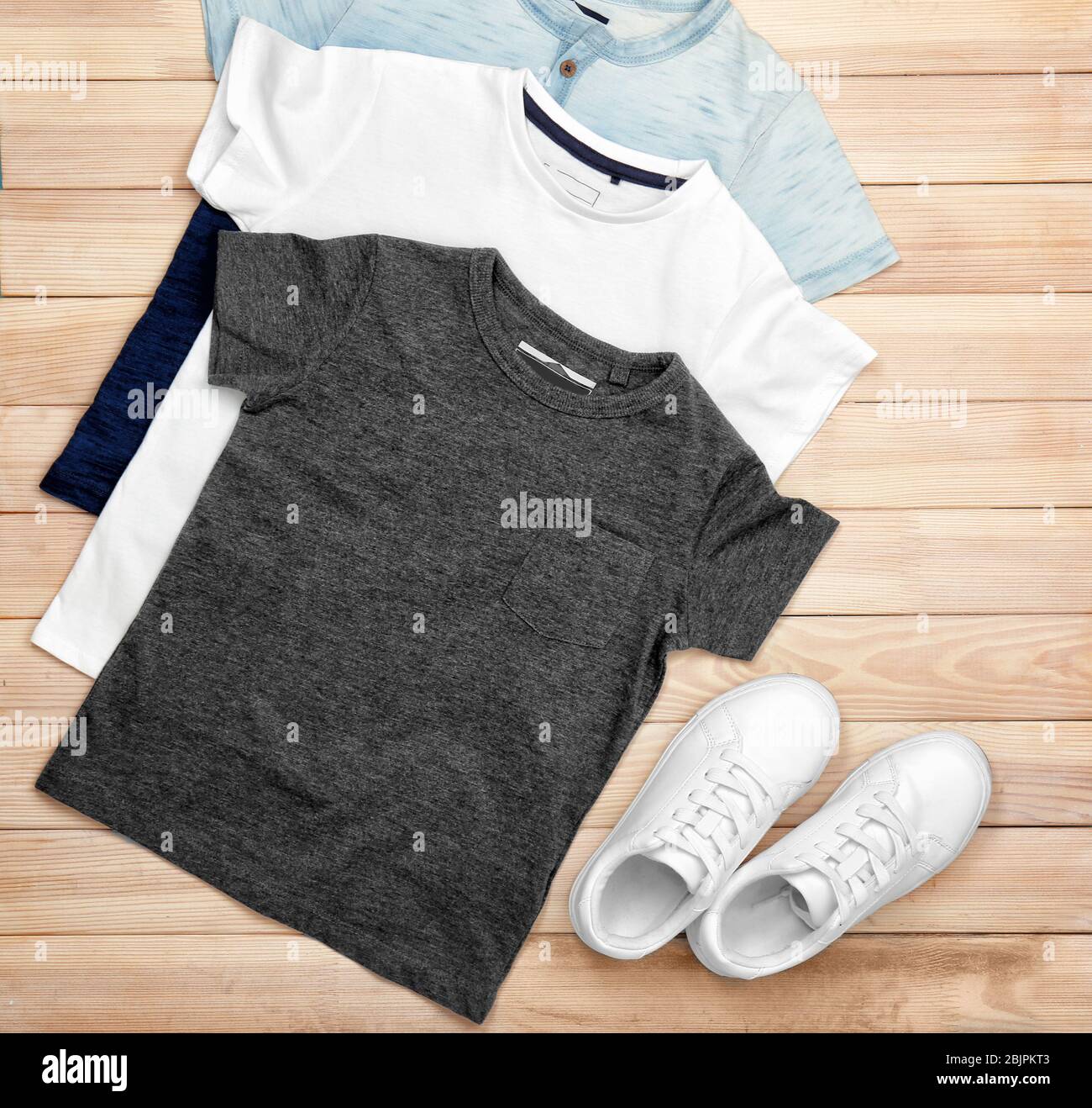 Set of child's clothes on wooden background Stock Photo - Alamy