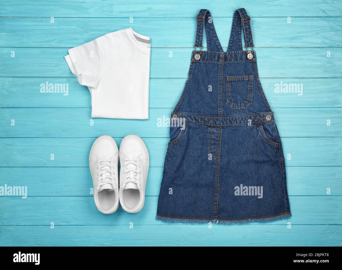 Set of child's clothes on wooden background Stock Photo - Alamy