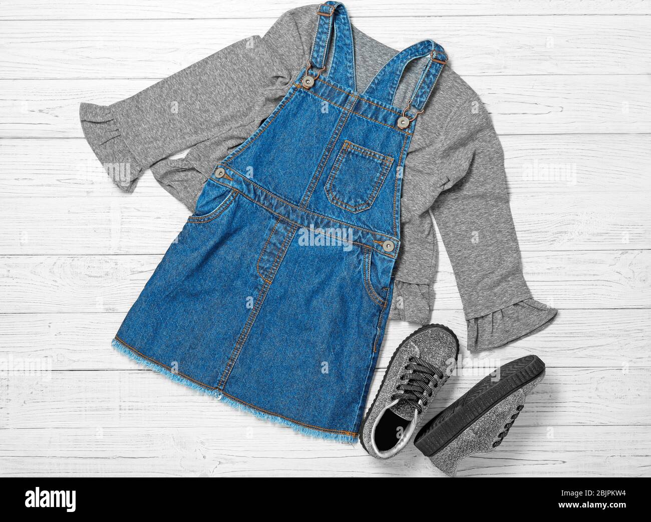 Set of child's clothes on wooden background Stock Photo - Alamy