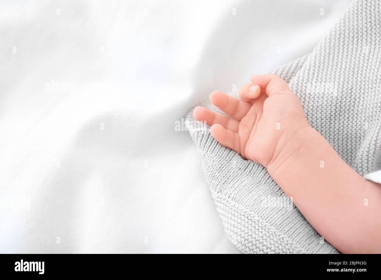 Baby hand on bed, closeup Stock Photo - Alamy