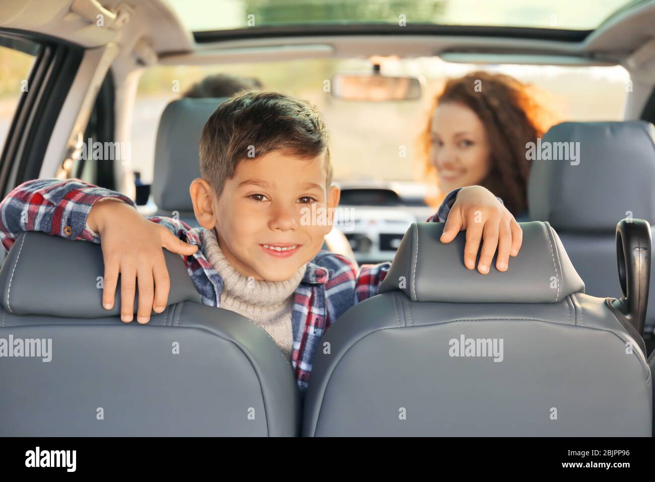 Cute boy with parents in car Stock Photo - Alamy