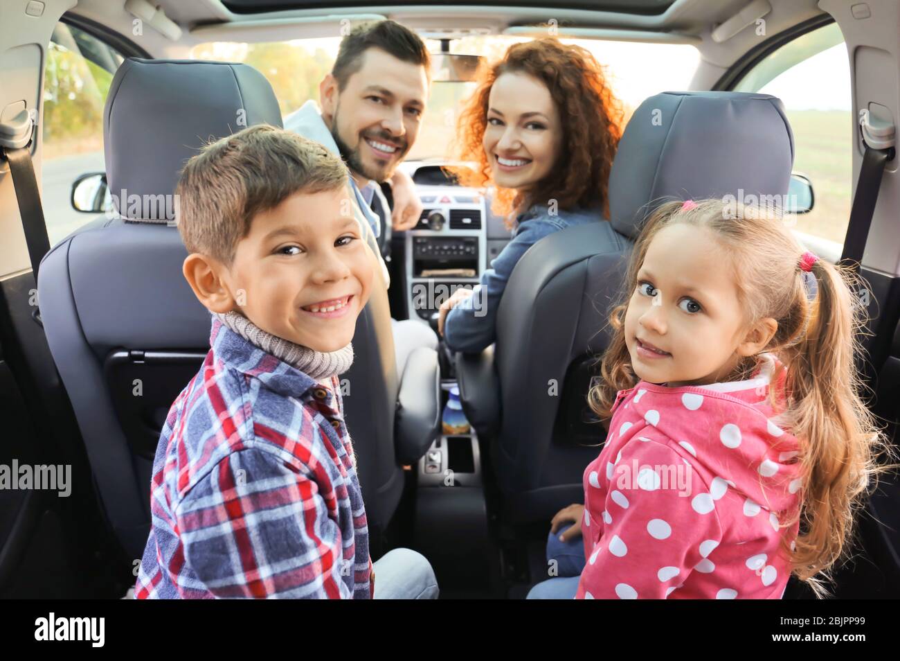 Cute children with parents in car Stock Photo - Alamy