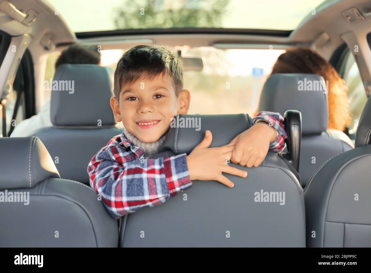 Cute boy with parents in car Stock Photo - Alamy