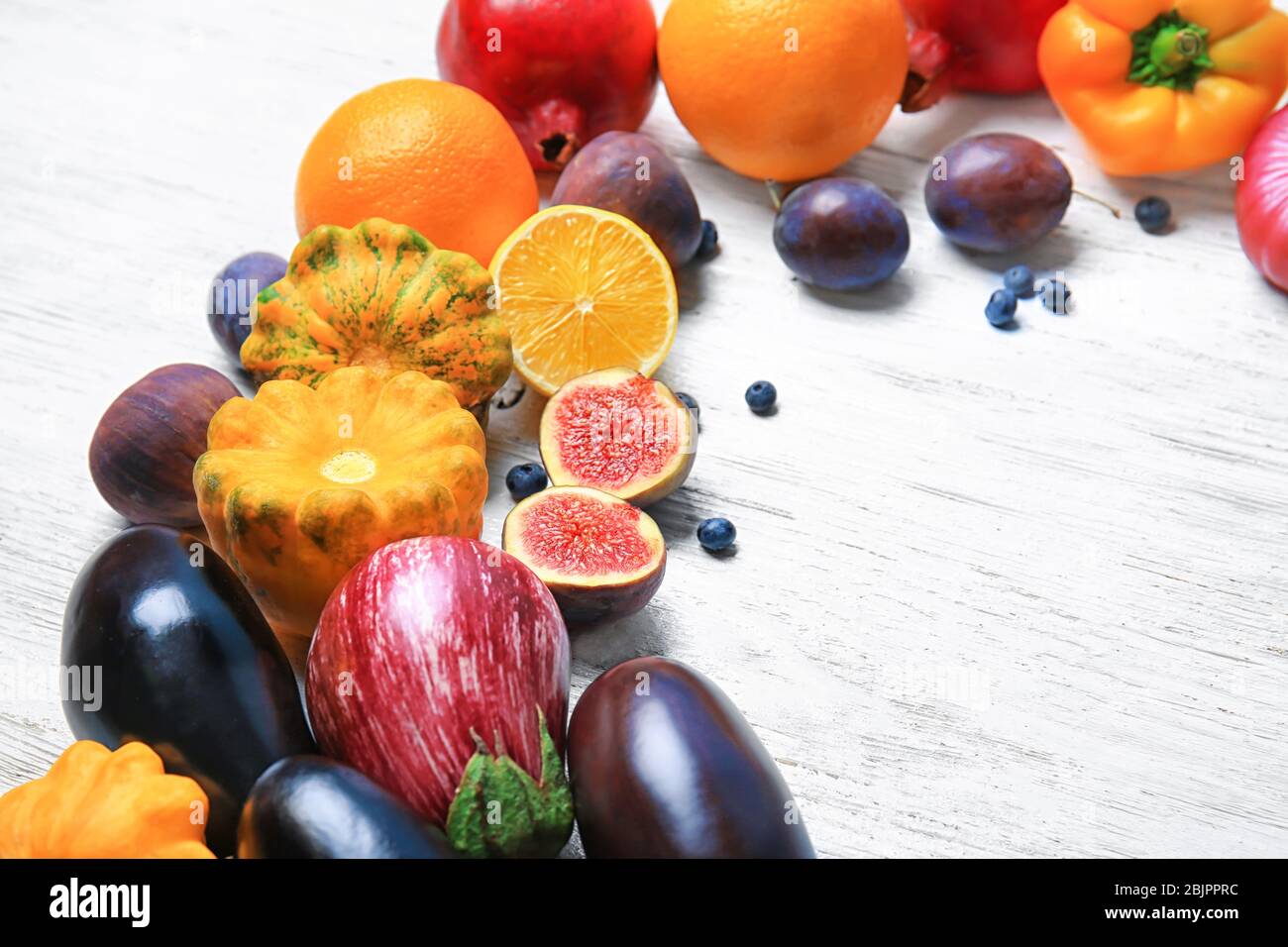 Composition of different fruits and vegetables on white wooden ...