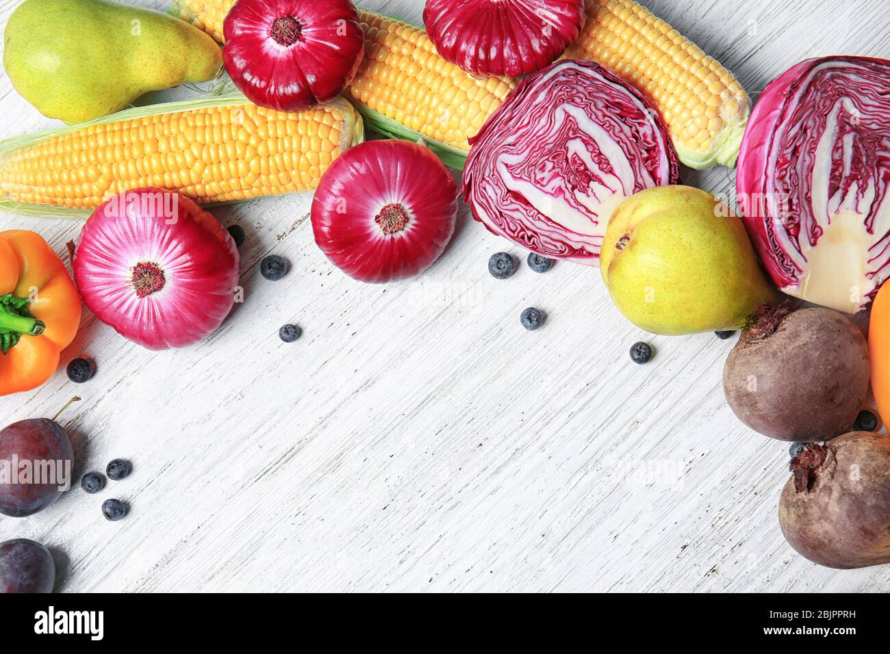 Composition of different fruits and vegetables on white wooden ...