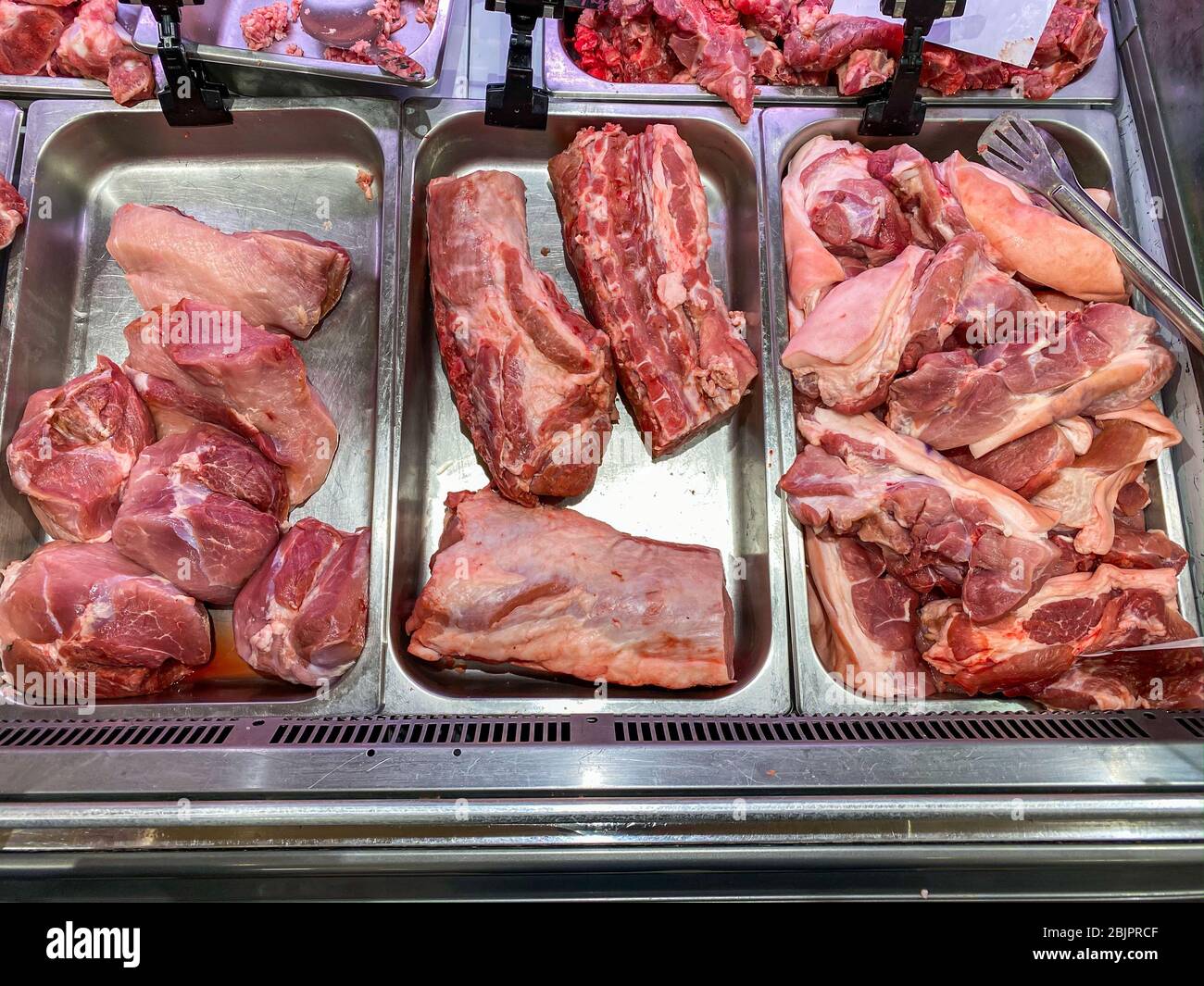 Raw pork meat for sale at butcher stall in supermarket Stock Photo - Alamy