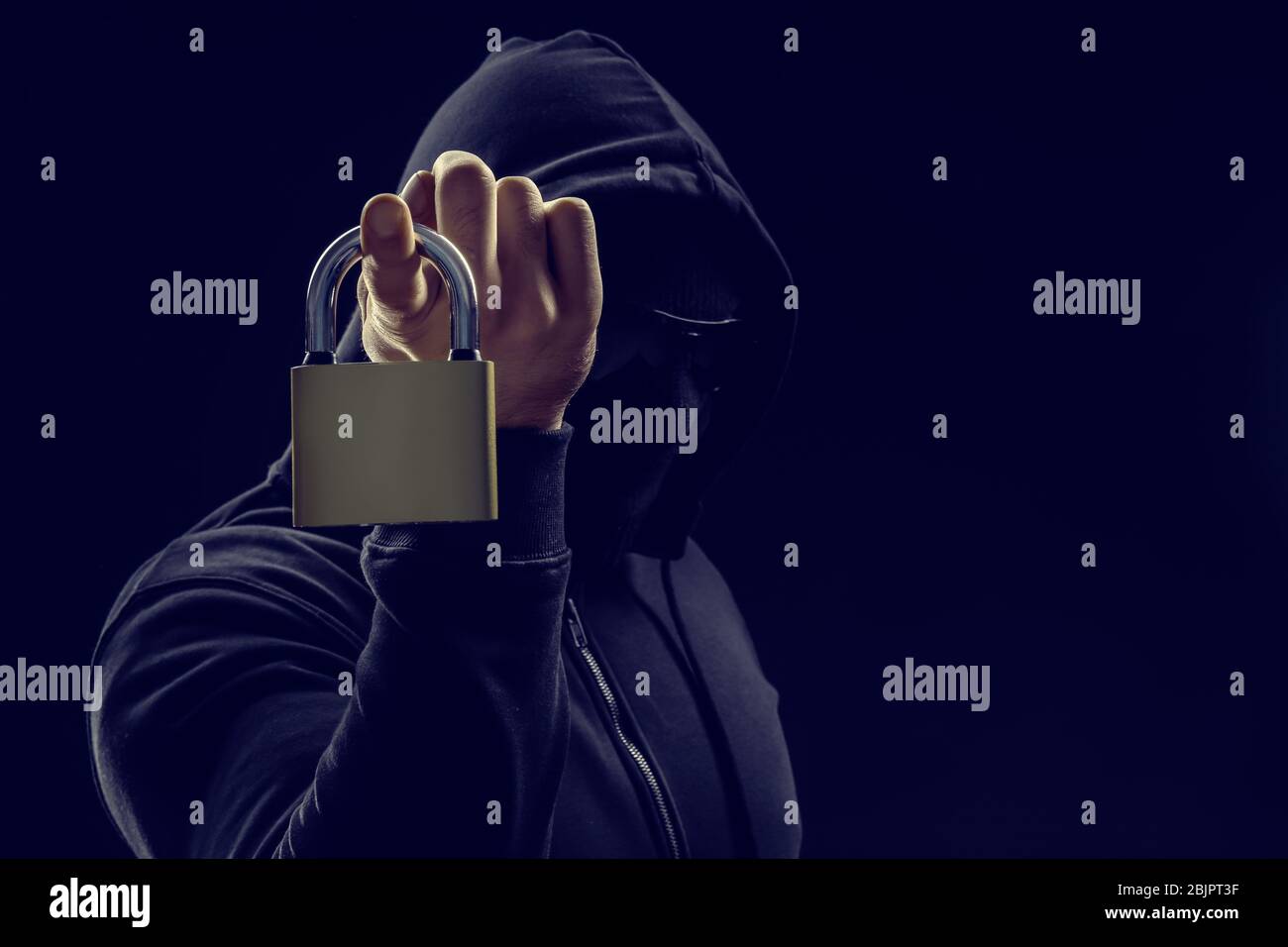 Hacker with lock on dark background Stock Photo - Alamy