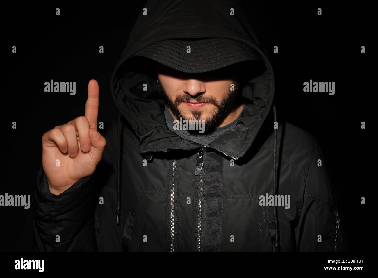 Hacker pushing button on virtual screen against dark background Stock ...