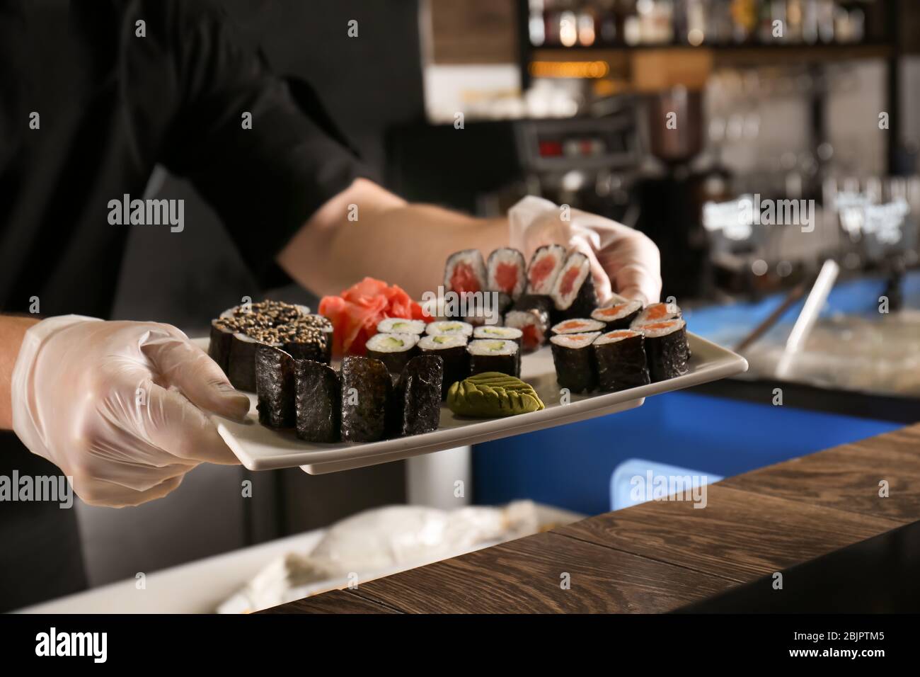 Chef with plate of tasty maki rolls in restaurant Stock Photo - Alamy