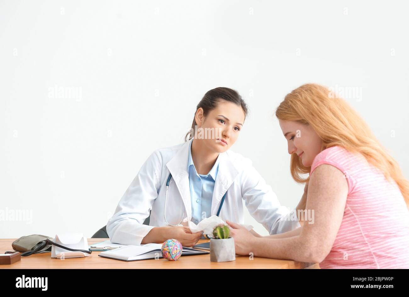 Young female doctor consulting overweight woman in clinic Stock Photo ...