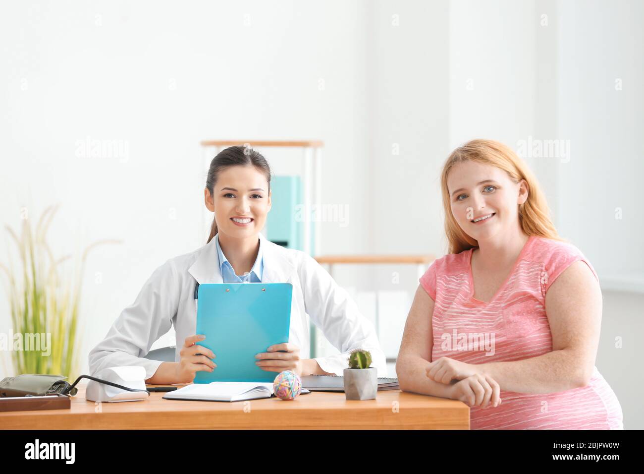 Young female doctor consulting overweight woman in clinic Stock Photo ...