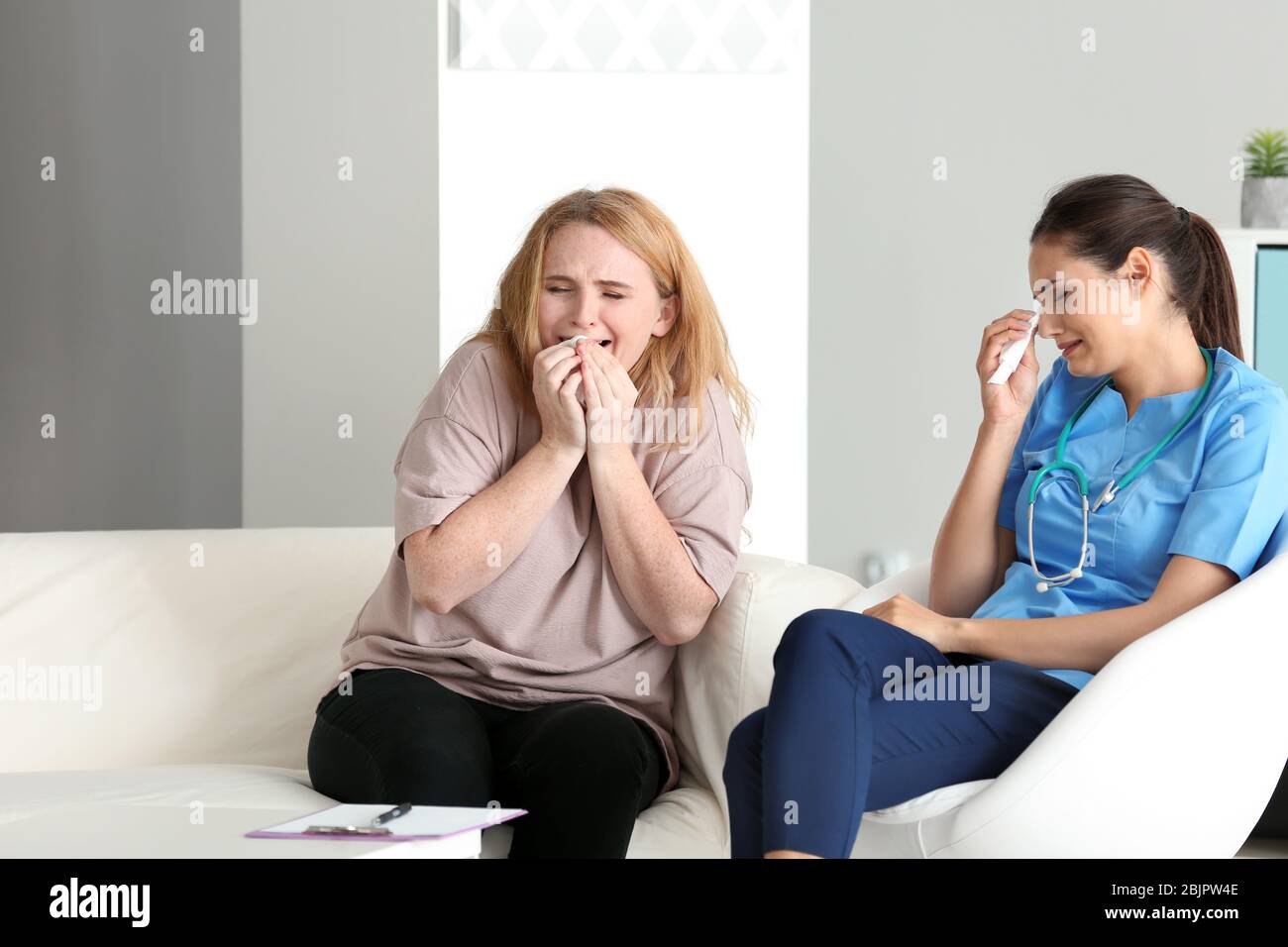 Young female doctor consulting overweight woman in clinic Stock Photo ...