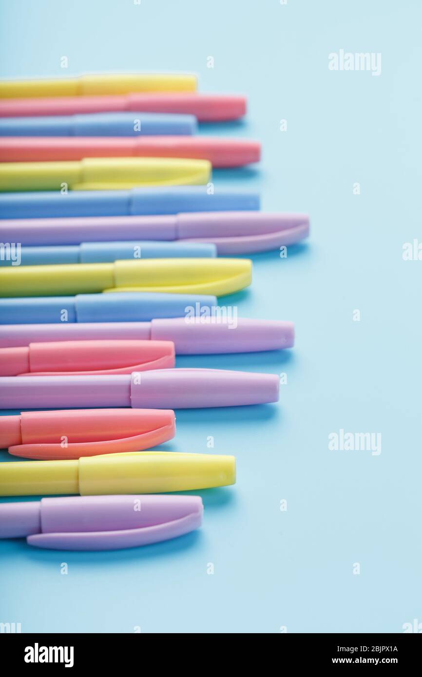 Multi-colored markers on a blue background with free space ...