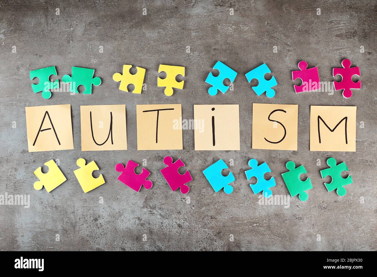 Composition with different puzzles and word AUTISM on grey background ...