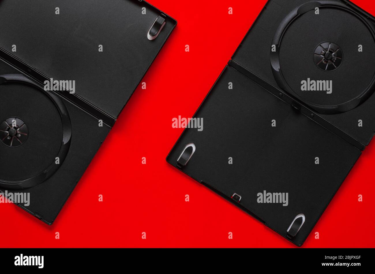 Open Empty DVD Boxes On A Red Background. Two plastic boxes for compact ...