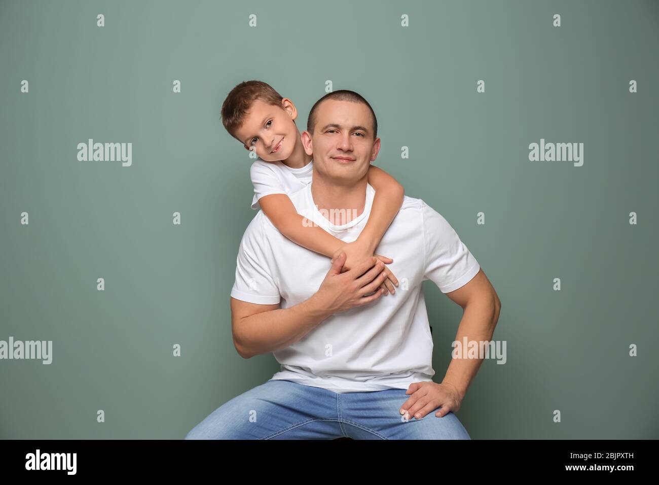 Dad and his son on color background Stock Photo - Alamy