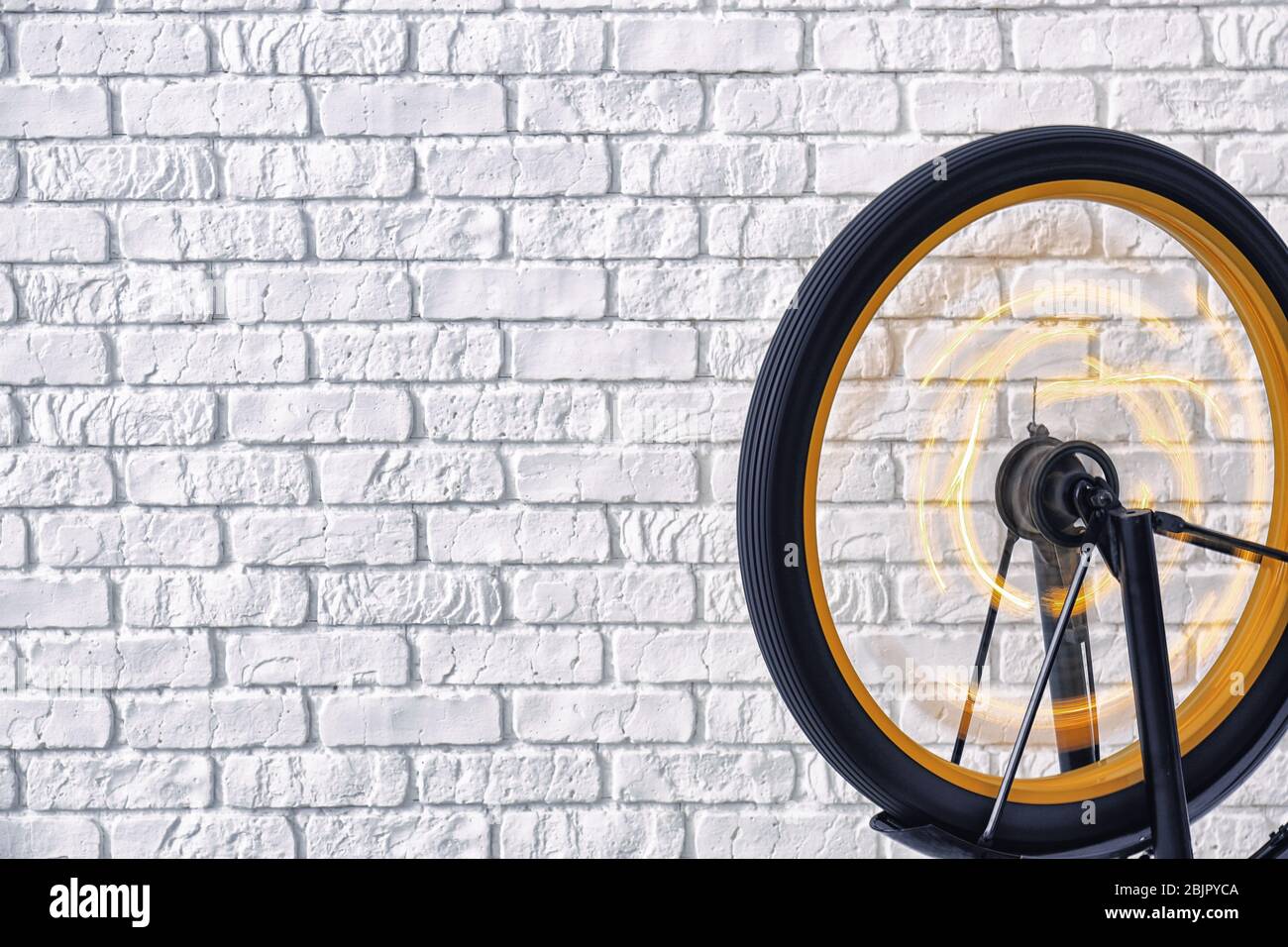 Spinning wheel of bicycle near brick wall Stock Photo - Alamy