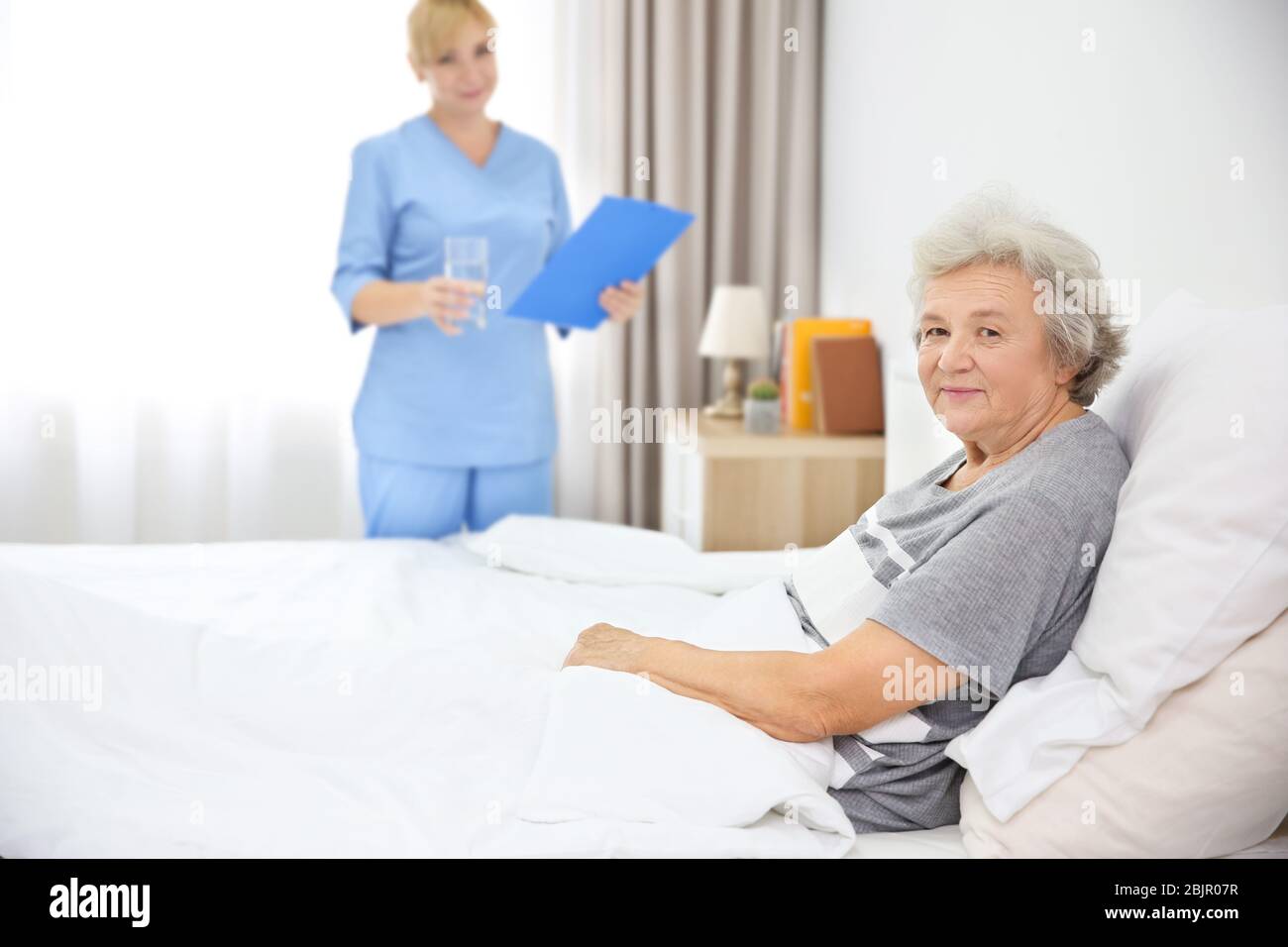 Senior woman with caregiver at home Stock Photo - Alamy