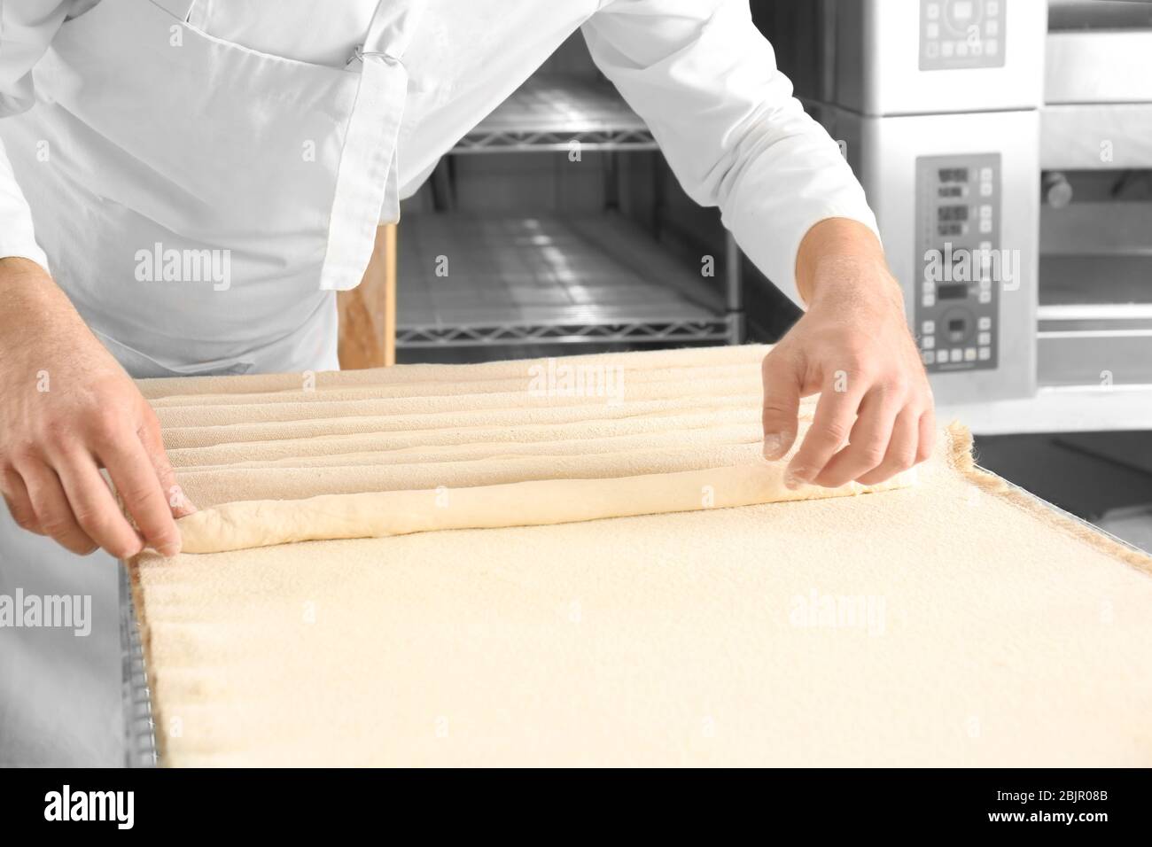 Man cooking delicious French bread in bakery Stock Photo - Alamy