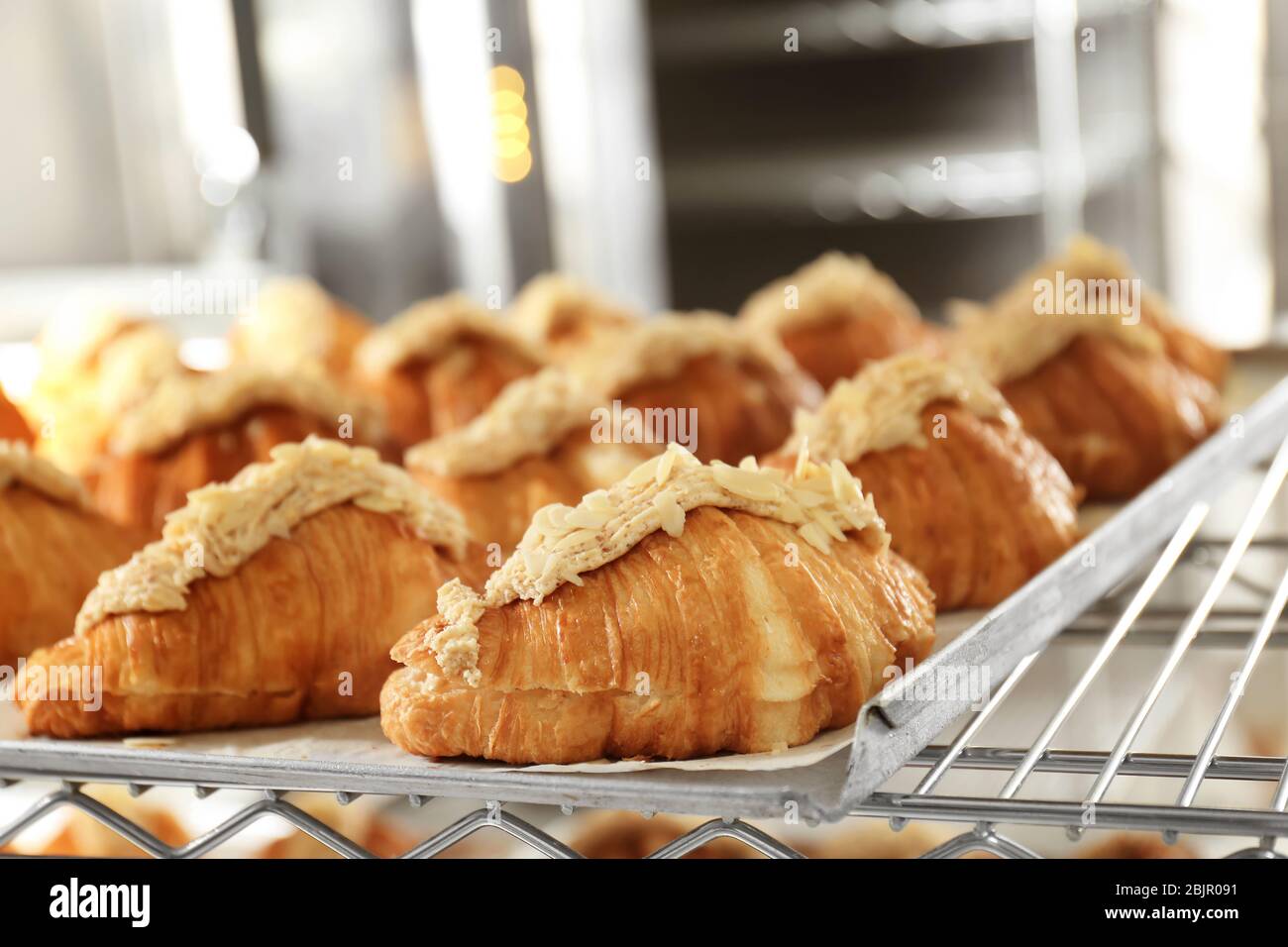 Shelf with delicious sweet croissants on tray in bakery Stock Photo - Alamy