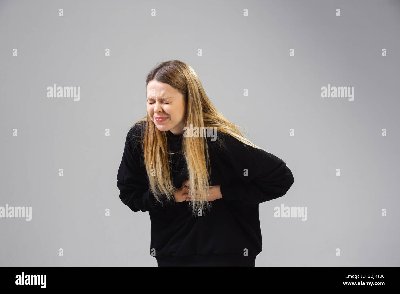 Young caucasian woman suffers from heartache, feels sick, ill and ...